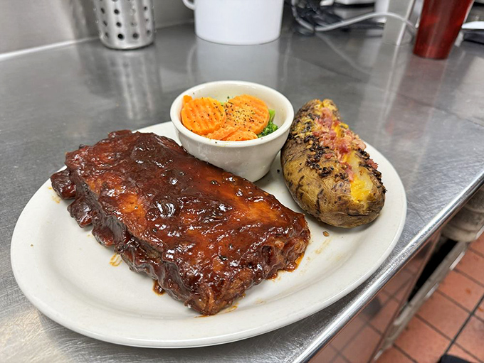 BBQ ribs glazed with a sauce so shiny you could check your reflection in it, alongside a loaded baked potato. Napkins: mandatory.
