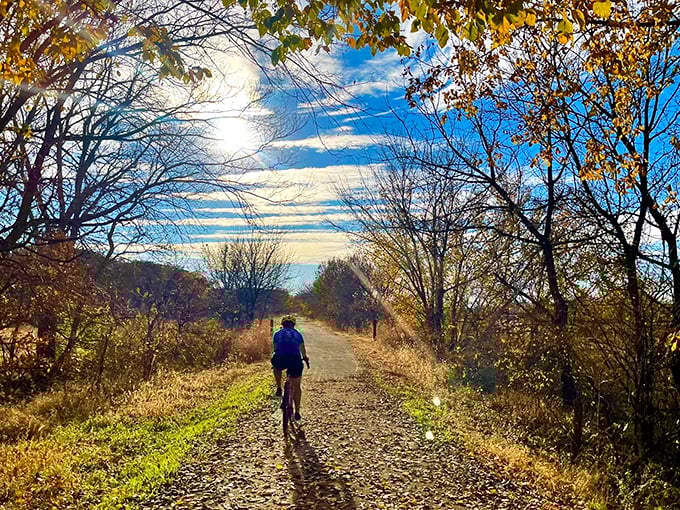 The Blue River Rail Trail beckons cyclists into a cathedral of autumn trees. This converted railroad path proves flat doesn't mean boring in the heartland.