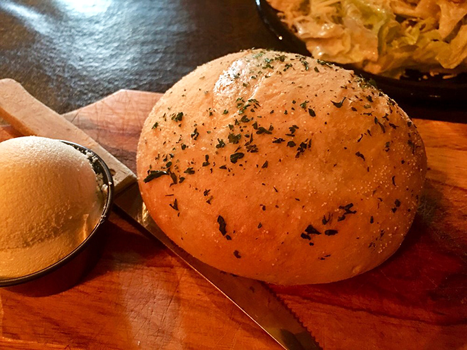 Warm, herb-flecked bread that's both precursor and supporting player—a simple pleasure that sets the stage for what's to come.