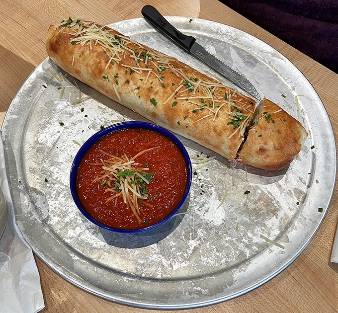 A calzone so perfectly bronzed it could win a tanning competition, served with marinara that demands to be dunked into.
