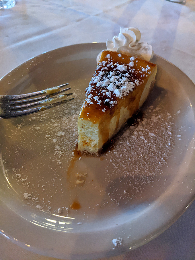 A slice of cheesecake that understands restraint&mdash;creamy perfection with a dusting of powdered sugar that knows how to make an elegant exit.