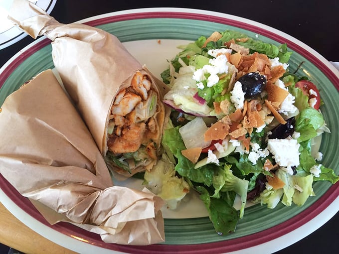 The chicken shawarma wrap, artfully bundled like a present, sits beside a fattoush salad that's practically doing a victory dance on the plate.