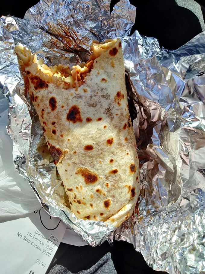 A burrito caught in its natural habitat: aluminum foil. Inside lies a treasure of flavors more valuable than anything in Fort Knox.
