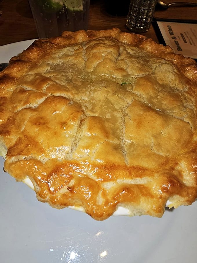 This golden-crusted chicken pot pie isn't just comfort food—it's a time machine to when dinner required both a knife and a satisfying steam release.