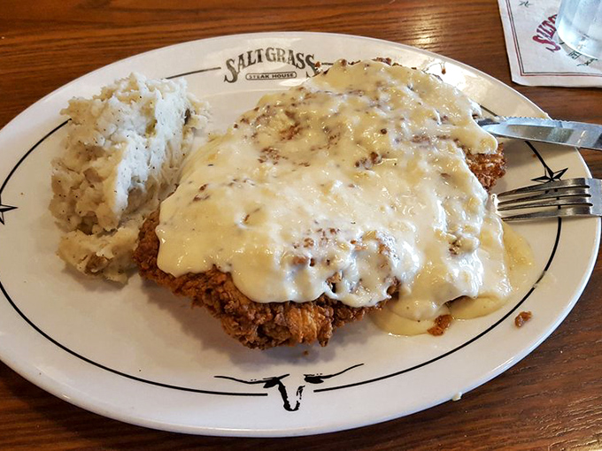 Country fried steak swimming in creamy gravy—Southern comfort food that gives you a warm, reassuring pat on the back with every bite.