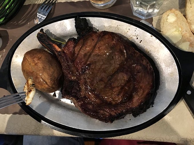 The Cowboy Ribeye arrives like a carnivorous statement piece&mdash;a baked potato sidekick loyally standing by as you contemplate where to begin.