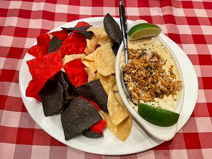 A creamy crab dip surrounded by tri-colored chips &ndash; ocean meets mountain in a dish that bridges coastal luxury with Western hospitality.