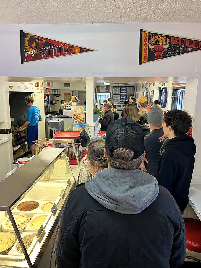The line of pilgrims waiting for their moment of hot dog transcendence. Some journeys are measured in miles, others in minutes of anticipation.