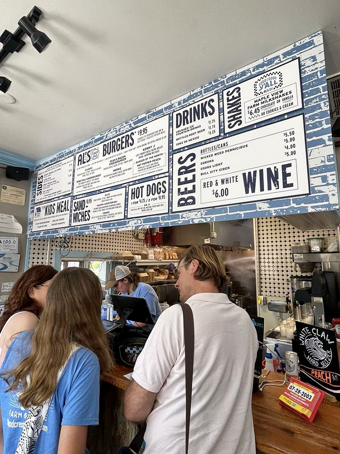 The menu looms large while patrons place their orders. This is the moment of delicious anticipation before burger bliss.