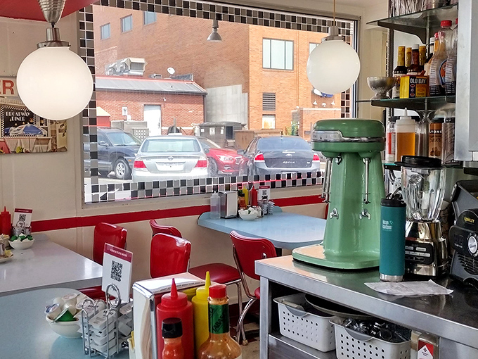 The view from your booth &ndash; red chairs, globe lights, and the promise of classic American diner magic just waiting to unfold.