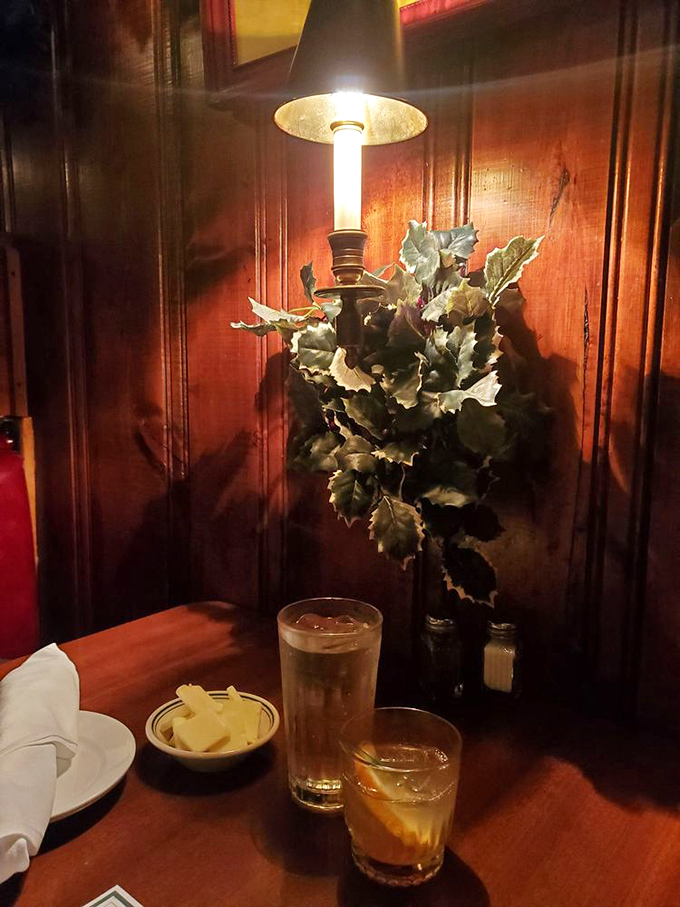 A perfectly mixed Old Fashioned waits beside a water glass. The Pine Club's cocktails honor tradition while the butter dish stands ready.