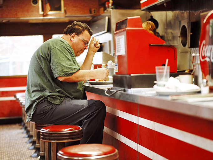 A solitary diner finds communion with his breakfast&mdash;a quiet moment of contemplation in the temple of eggs and coffee.