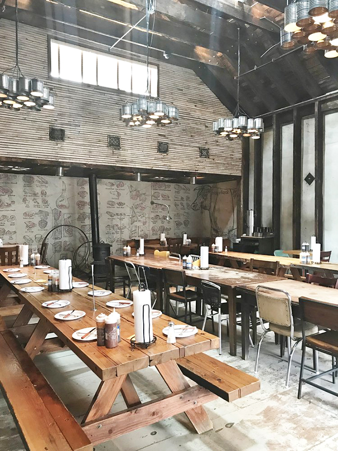 Picnic tables indoors? Genius! The butcher diagram wallpaper subtly reminds you exactly which delicious parts of the animal you're enjoying.