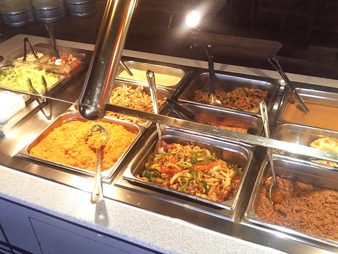 The lunch buffet stands ready for action, each steaming tray offering a different path to satisfaction. Choose wisely, or better yet, try them all.