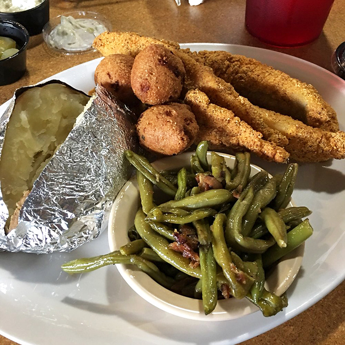 Southern comfort on a plate: cornmeal-crusted catfish, hushpuppies, and green beans cooked with enough bacon to make vegetables count as indulgence.
