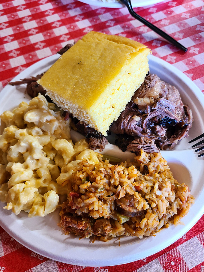 The holy trinity of barbecue bliss: fork-tender meat, sunny cornbread, and sides that don't know they're supposed to play supporting roles.
