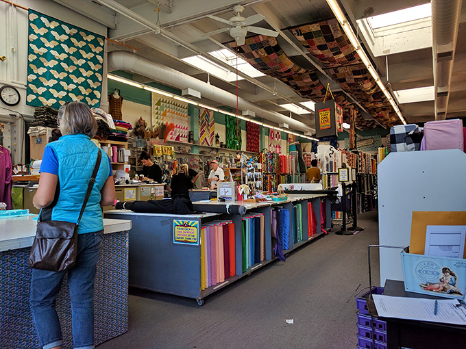 The cutting counter serves as command central, where fabric dreams are measured, cut, and sent home to fulfill their creative destiny.