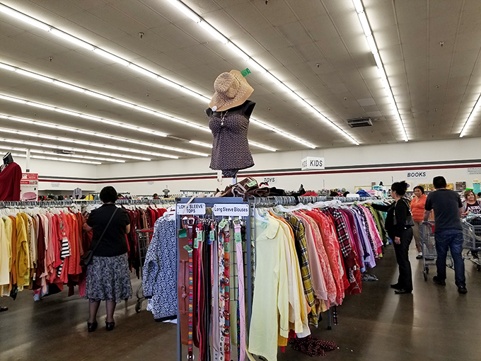 Racks of possibility stretch toward fluorescent horizons, a landscape of fashion where every item tells a different story.