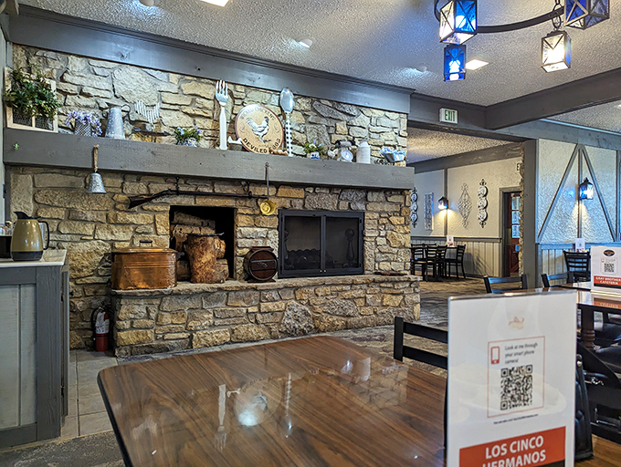 The stone fireplace anchors the dining room like a hearth from another era, promising warmth that goes beyond temperature.
