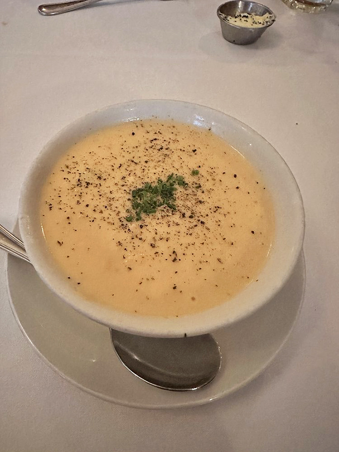 Lobster bisque so velvety smooth it could make silk jealous. That sprinkle of herbs is like putting a bow on perfection.