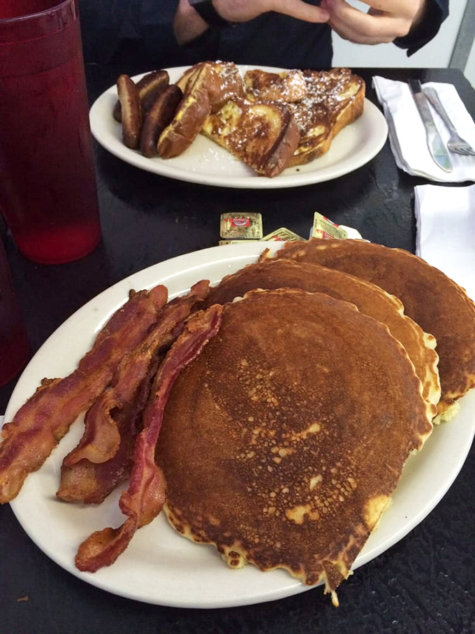 Pancakes so perfectly golden they belong in Fort Knox, with bacon crisp enough to make vegetarians question their life choices.