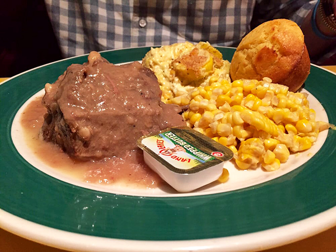 Pot roast so tender it surrenders at the sight of your fork, accompanied by corn that tastes like summer and a cornbread muffin crown.