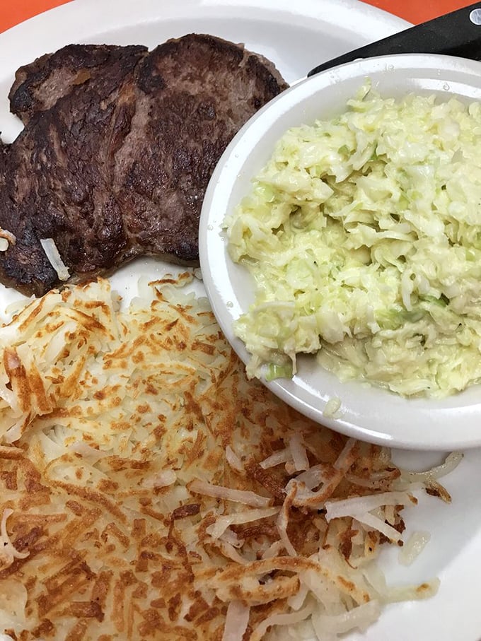 The holy trinity of diner excellence &ndash; perfectly seared ribeye, golden hash browns with crispy edges, and creamy slaw creating the perfect balance of textures.