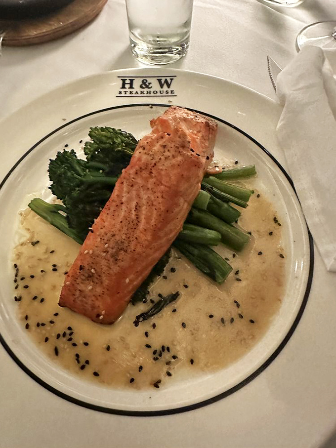 Salmon gets the royal treatment, perched atop vibrant vegetables in a sauce that proves H&W's excellence extends beyond beef.