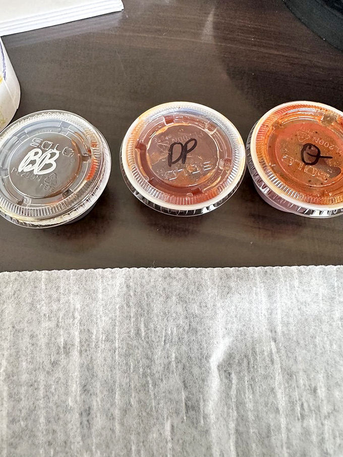BBQ sauce containers marked with cryptic codes, like treasure maps to flavor country. Choose your adventure wisely.