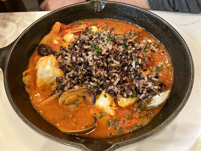 Seafood stew that rivals coastal offerings &ndash; a rich tomato broth cradles clams, shrimp and fish beneath a crown of nutty wild rice. 