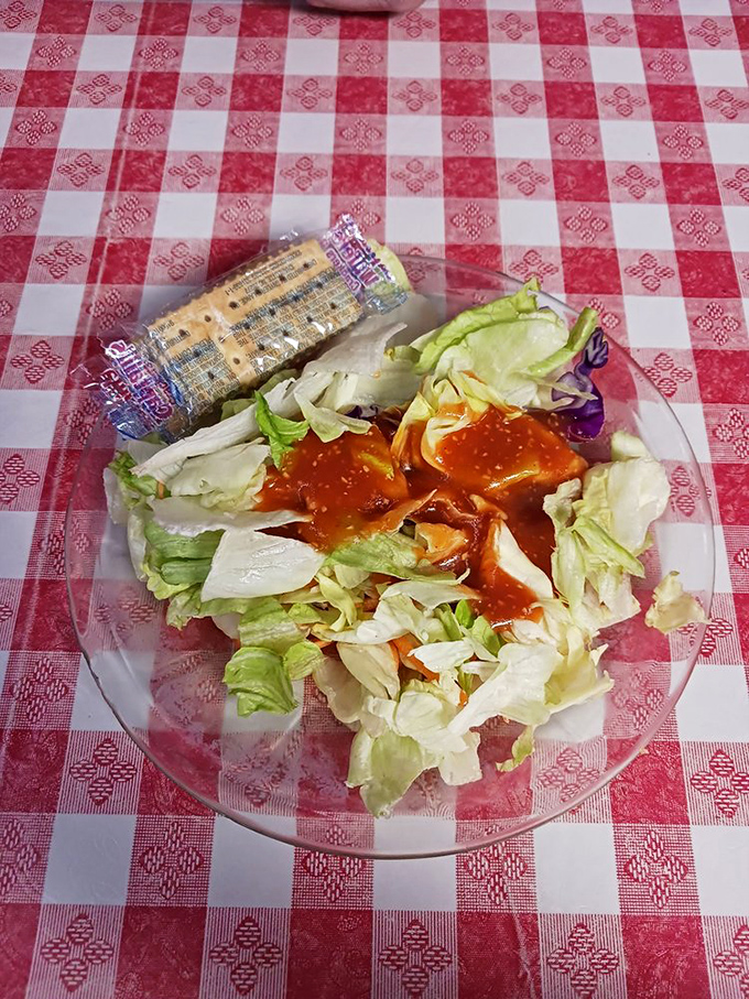 A simple side salad with French dressing that's playing its supporting role perfectly &ndash; the vegetable alibi for the feast to come.