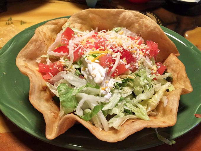 The taco salad arrives in its edible fortress, a crispy shell standing guard over a treasure of lettuce, cheese, and all things wonderful.
