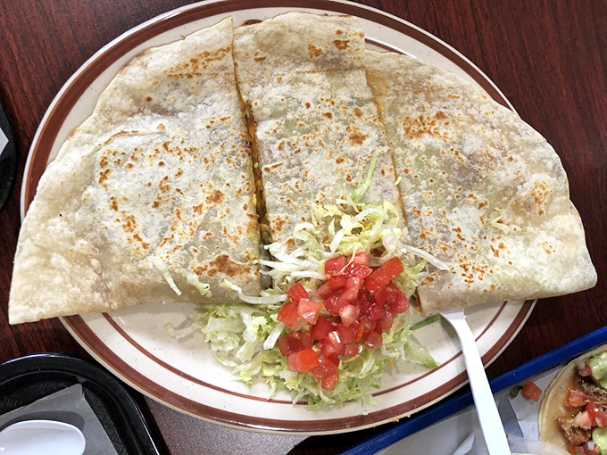 The quesadilla &ndash; that perfect compromise between a grilled cheese and a tortilla &ndash; executed with golden-brown precision and fresh toppings standing by.