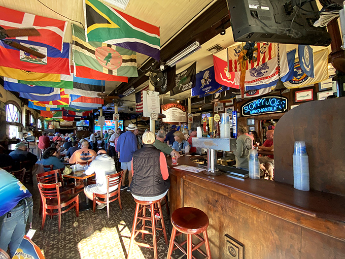 The afternoon crowd settles in beneath flags from around the world, united by the international language of cold beer and good company.