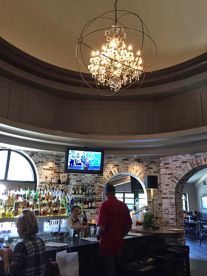 The bar area combines brick, crystal, and warm lighting to create a space where strangers become friends and happy hour extends to "happier hours."