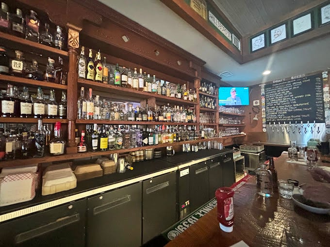The bar at Wooden Nickel isn't just stocked with bottles – it's loaded with possibilities, each shelf holding liquid stories waiting to be poured.