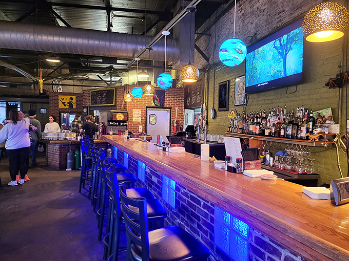 The bar area glows with blue light and possibility&mdash;where strangers become friends over shared love of melted cheese.