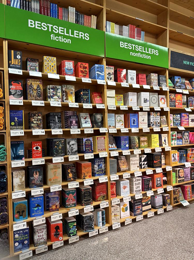 The bestseller wall presents a literary popularity contest where fiction and non-fiction compete for attention like siblings vying for the front seat.