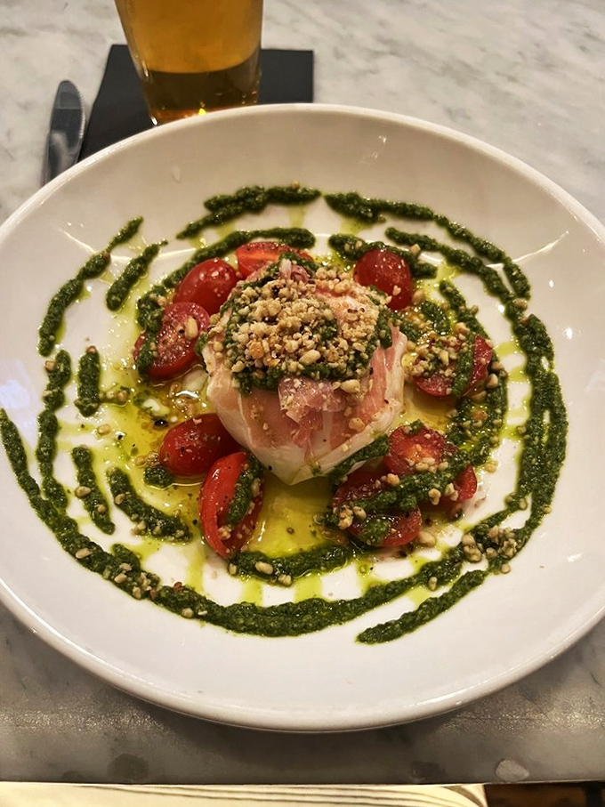 A plate that belongs in an art gallery. Burrata surrounded by tomatoes and pesto creates a canvas of flavors that's almost too beautiful to eat. Almost.