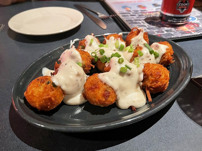 Golden-fried hush puppies (or perhaps spicy Cajun tots) arrive drizzled with creamy sauce&mdash;small bites that deliver big Southern comfort.