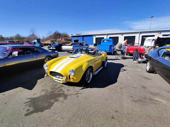 Car enthusiasts gather in the parking lot, where vintage beauties remind us that speed has always been stylish.