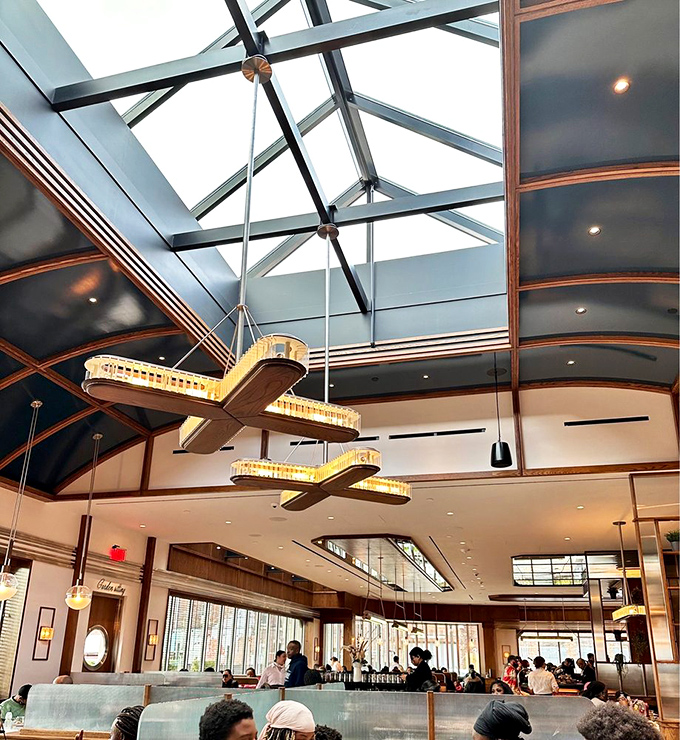 Soaring ceilings with dramatic lighting fixtures create a cathedral-like atmosphere. Who knew worshipping at the altar of pancakes could be so architecturally inspiring?