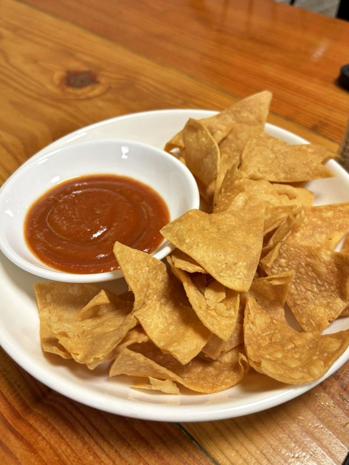 Green walls and decorative Mexican art create a vibrant backdrop that matches the bold flavors coming from the kitchen.