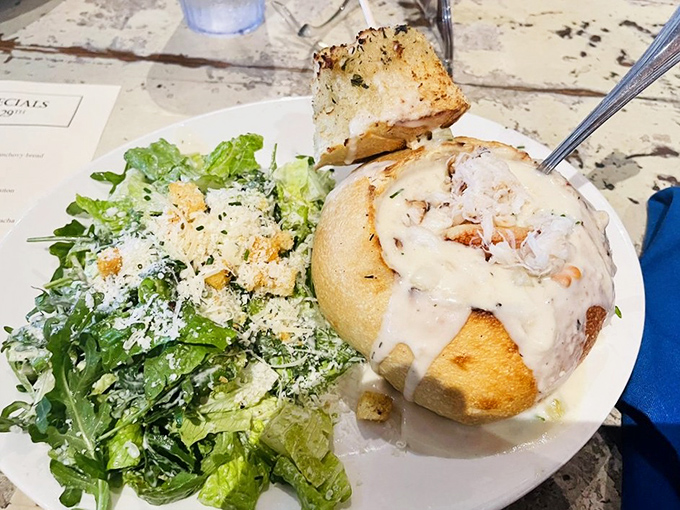Bread bowl overflowing with creamy chowder alongside a crisp Caesar. The ultimate comfort food duo that hugs your soul from the inside.