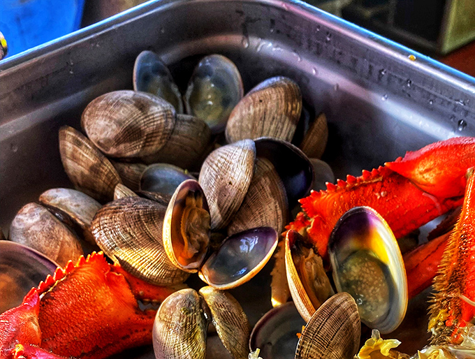 Nature's perfect appetizer&mdash;plump clams nestled alongside their crustacean cousins, creating a metal tray of maritime magnificence.