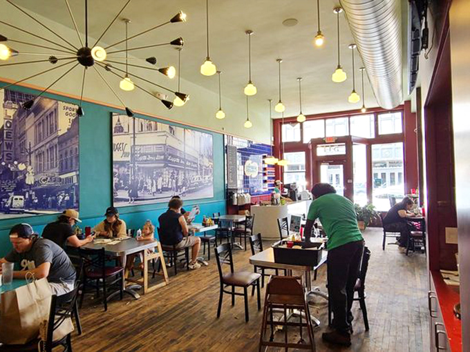 Where strangers become friends over shared syrup bottles. The vintage photos on turquoise walls tell stories between every bite.