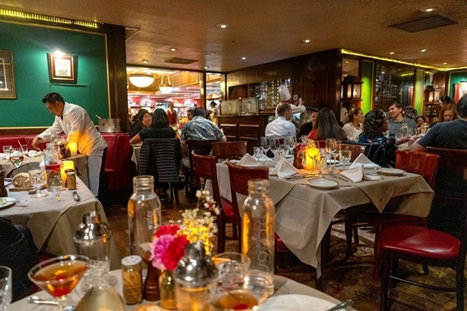 The dining room hums with conversation and anticipation as servers orchestrate the delicate dance of exceptional service amid satisfied patrons.