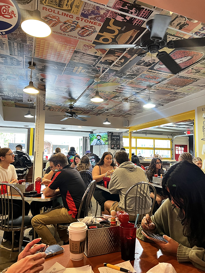 The ceiling plastered with vintage posters watches over a dining room where strangers become temporary breakfast companions in the pursuit of morning bliss.