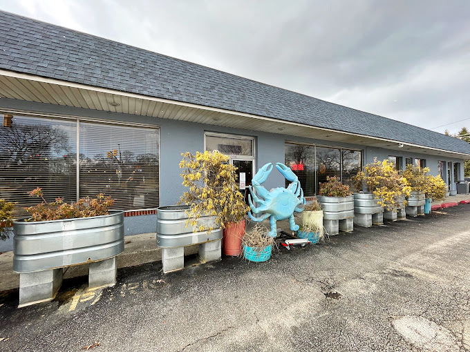 The blue crab sculpture stands guard, silently promising what awaits inside. He's seen things... delicious things.