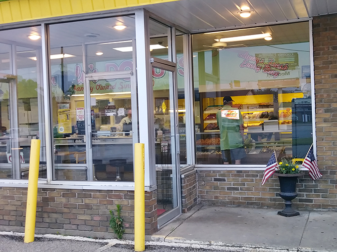 American flags flank the entrance like sentries guarding a national treasure. In many ways, this donut shop truly is.